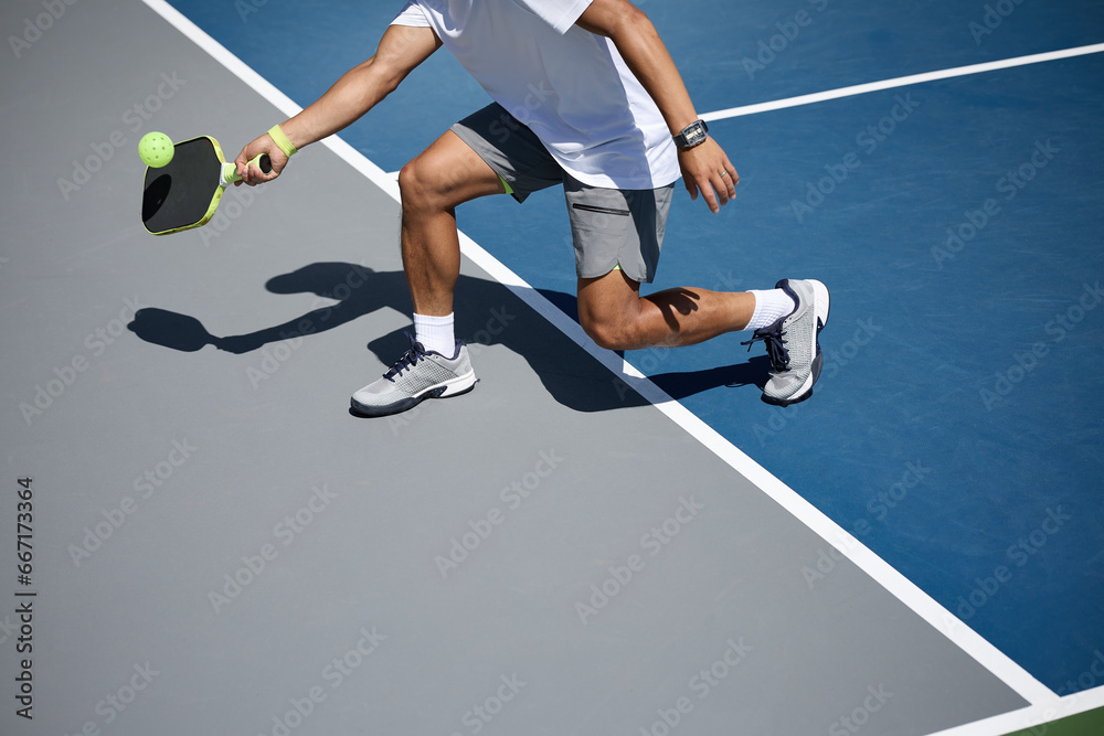 An athlete playing pickleball on a blue and gray court Stock Photo ...