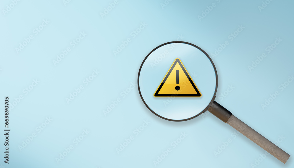 magnifier glass with yellow triangle caution warning sign on blue ...