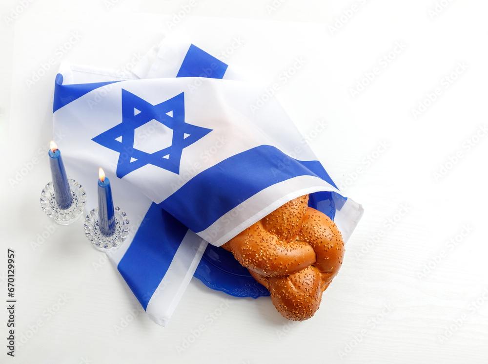 Challah bread covered with the Israeli flag, burning blue candles ...