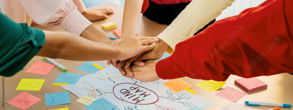 A group of business people putting their hands together at meeting room ...