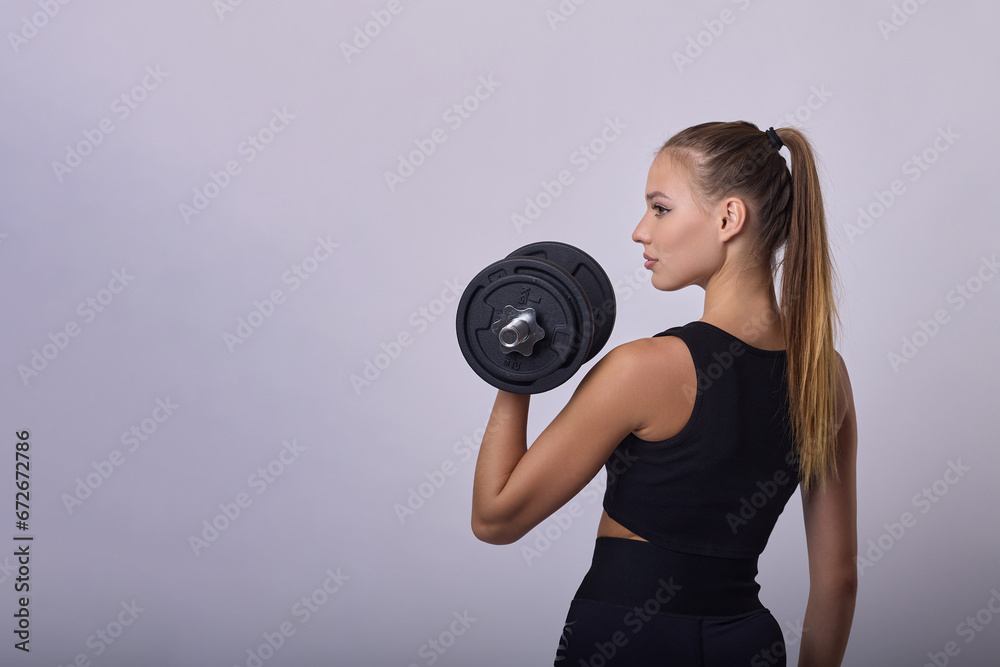 Home workouts with heavy dumbbells of a young girl, strengthens her ...