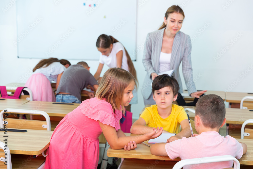 Interested preteen pupils divided into small groups, discussing ...