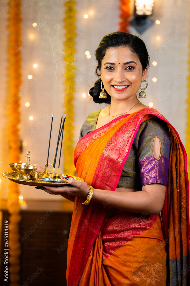 Vertical shot of happy indian girl in traditional ethnic wear holding ...