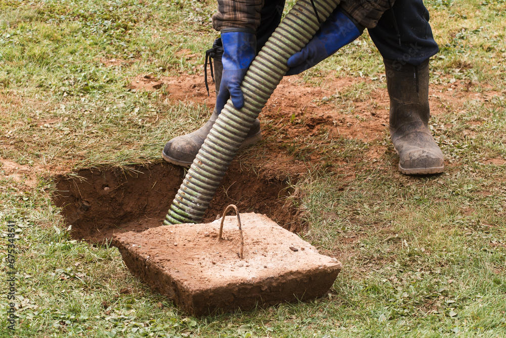 Waste management worker pumping out a residential septic tank. Stock ...