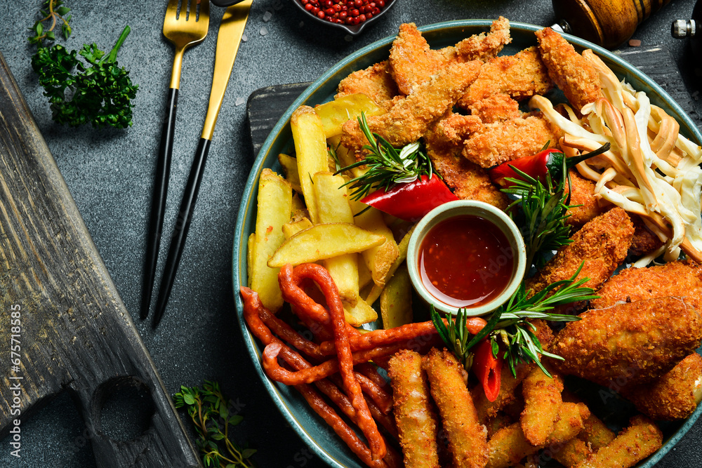 Fast food. Plate with snacks: nuggets, sausages, French fries, cheese ...