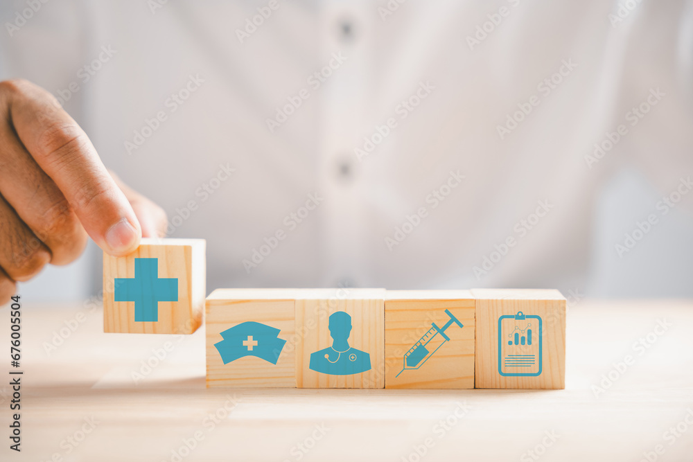 Symbolic image, Hand grips wooden block displaying healthcare and ...