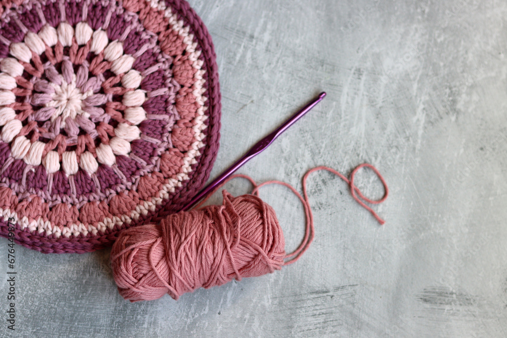 Pink and purple round crochet pattern on light grey textured background ...