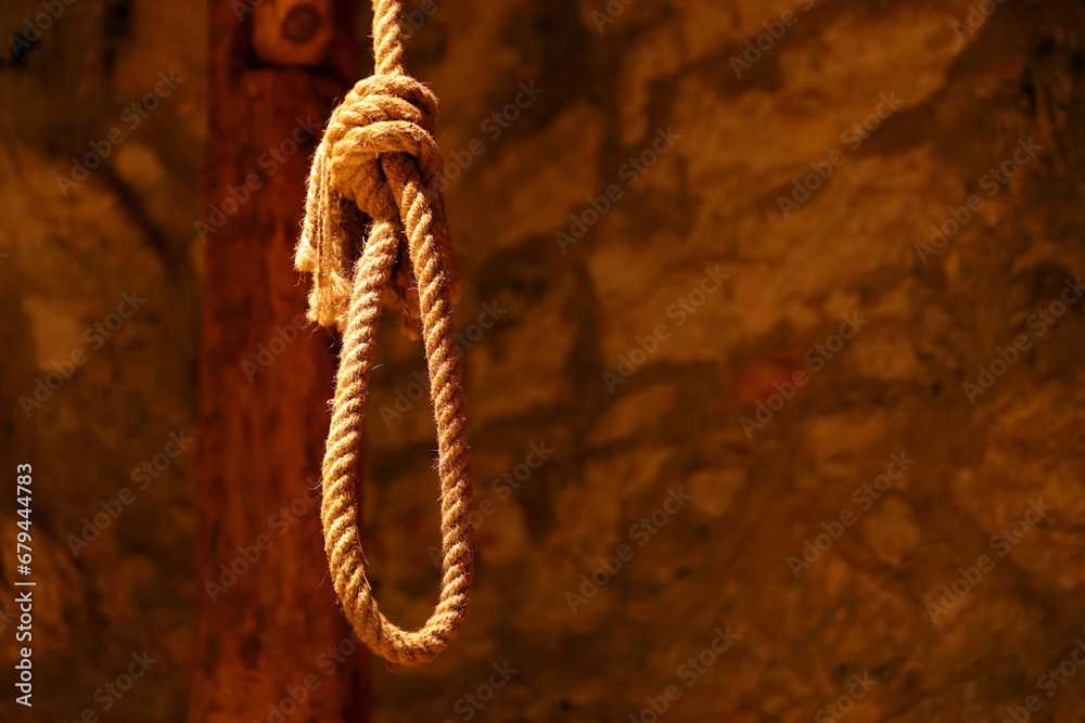 Noose in prison of old castle cellar and grunge stone wall close up ...