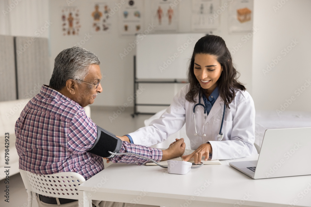 Positive young cardiologist doctor woman examining elderly geriatric ...