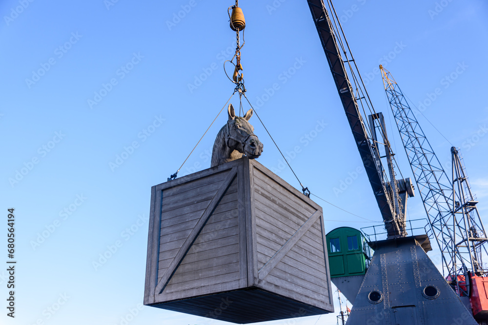 Crane holds a model of a crate containing a horse at the Port of ...