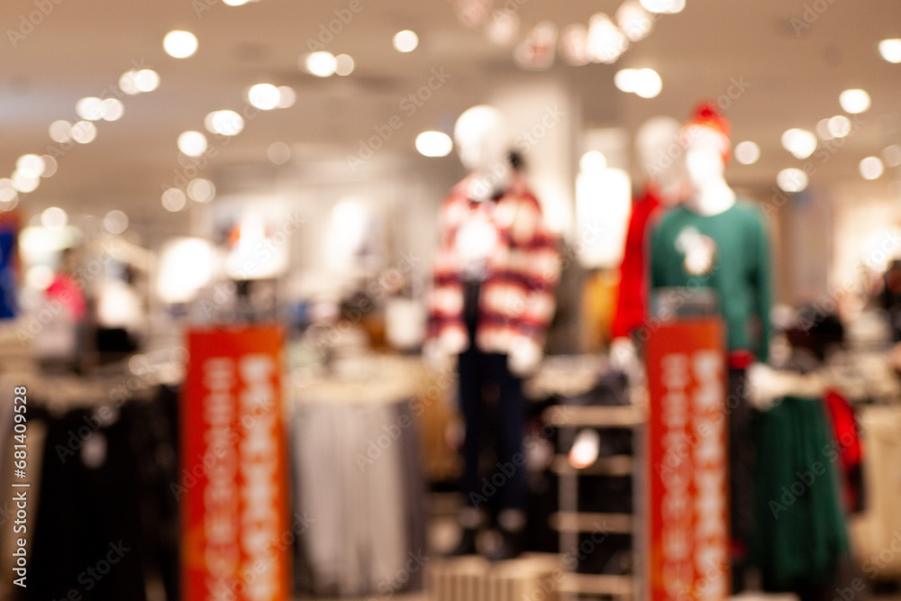 Blurry view of a bustling mall interior with various shops and ...