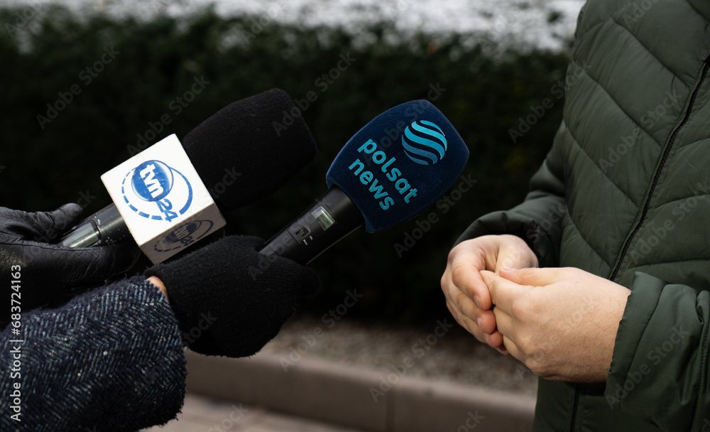 Reporters during interview, holding microphones with logo sign of ...