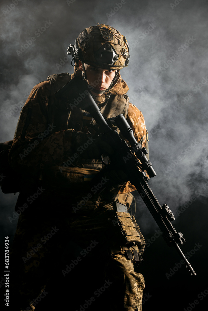 An army soldier in a military camouflage uniform, a helmet and a mask ...