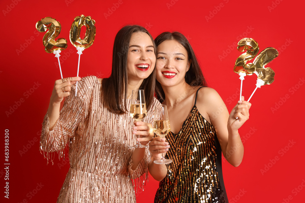 Beautiful young women with champagne and figure 2024 on red background ...