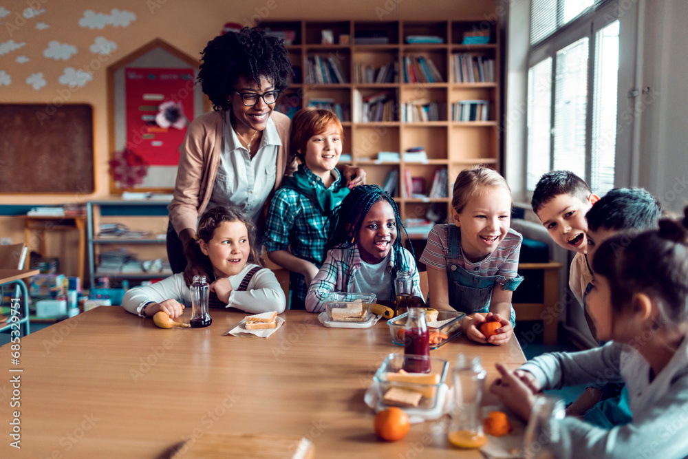 Little children having lunch break in elementary classroom Stock Photo ...