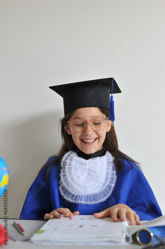 formanda infantil com beca e capelo uniforme de formatura em mesa ...