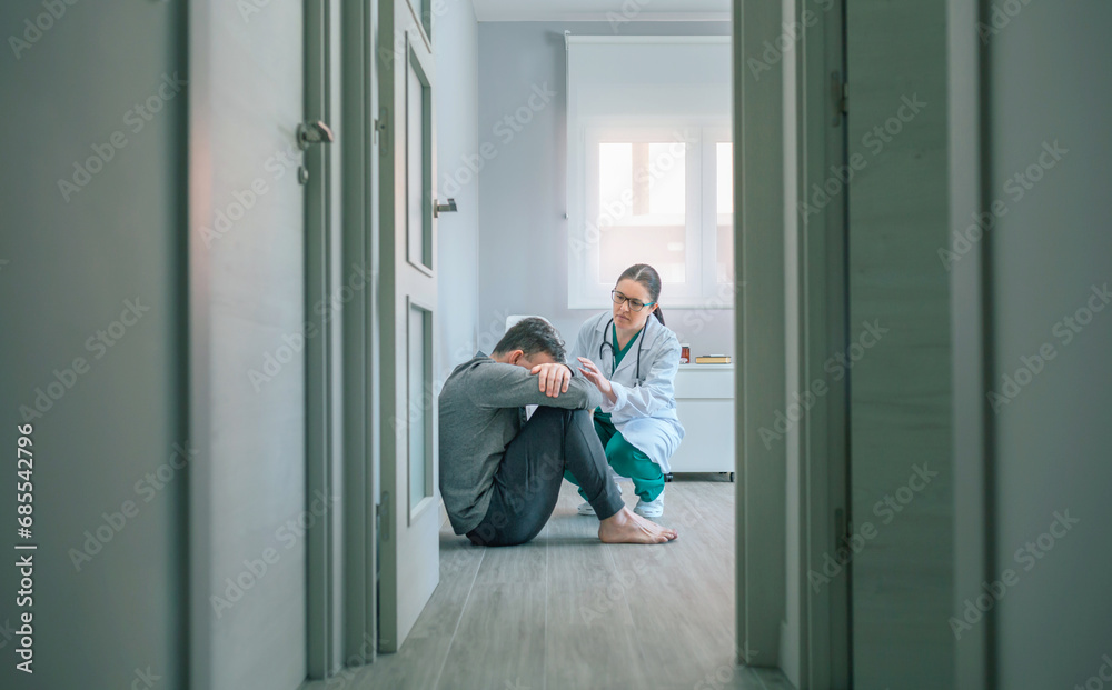 Female psychiatrist talking to male patient with mental disorder and ...
