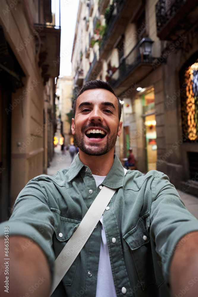 Happy vertical selfie of a young caucasian man in an old town of ...