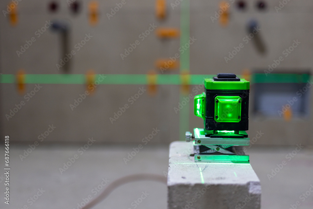 Glowing green laser spirit level built on a brick at a construction ...