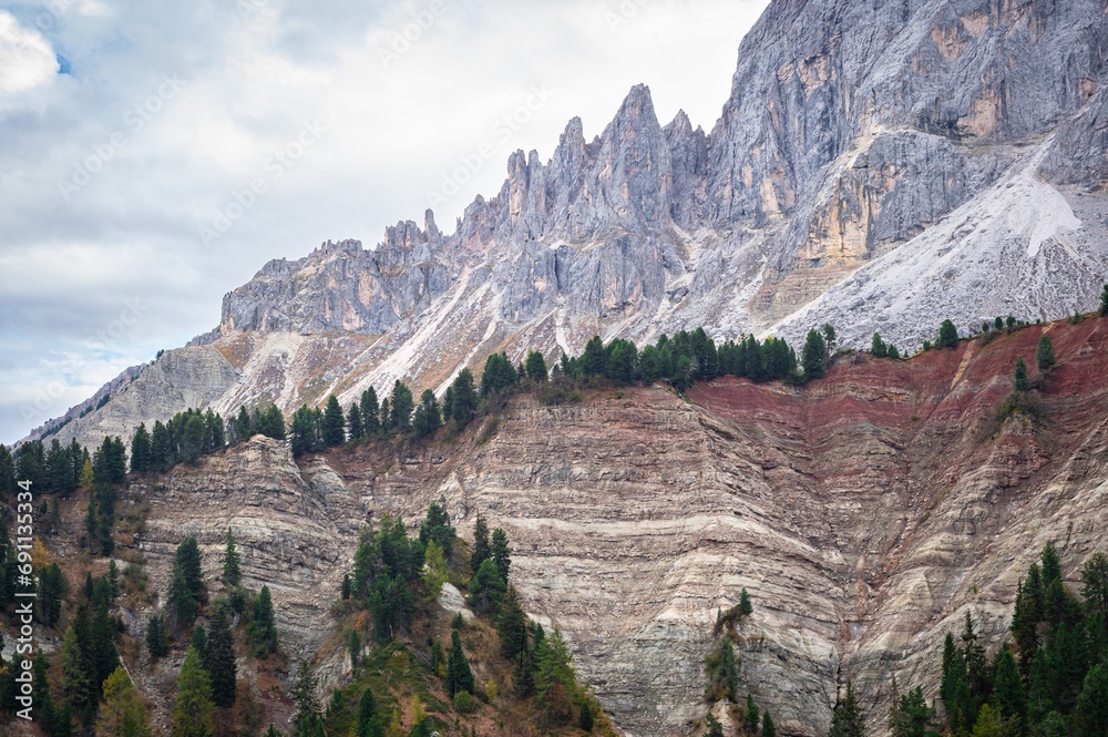 Magnificent view of a red-coloured cliff covered with spruce trees at ...