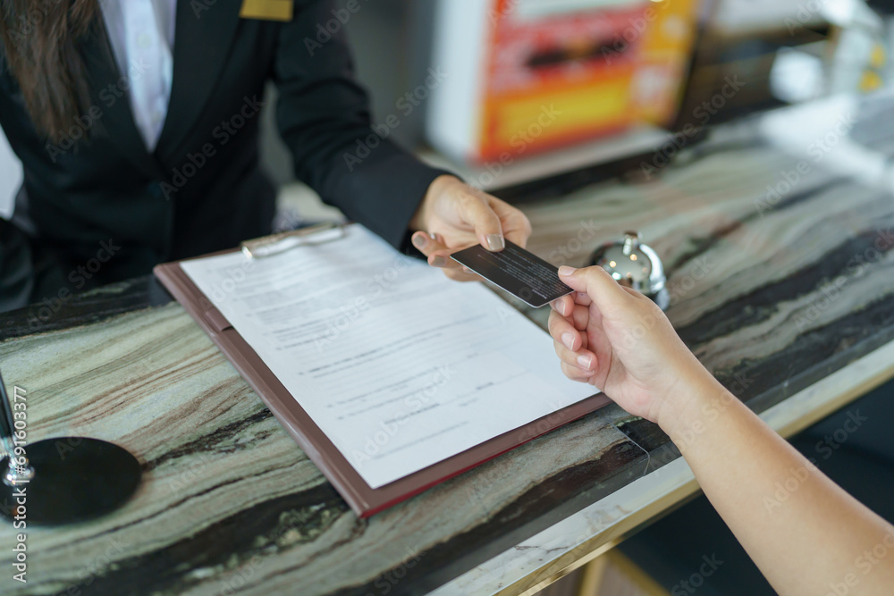 Hotel receptionist in uniforms Concierge giving the key doing check-in ...