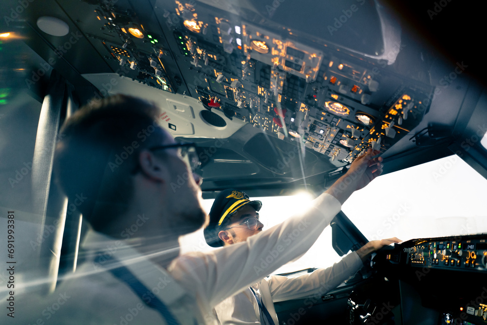 young pilots in the cockpit of the plane control the air transport ...