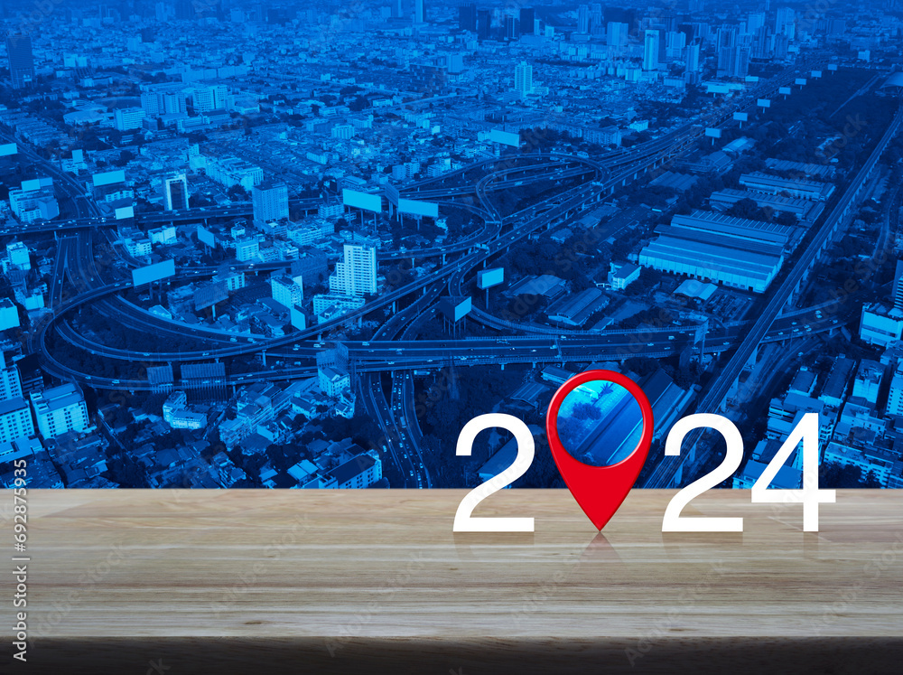 2024 letter with map pin location icon on wooden table over modern city ...