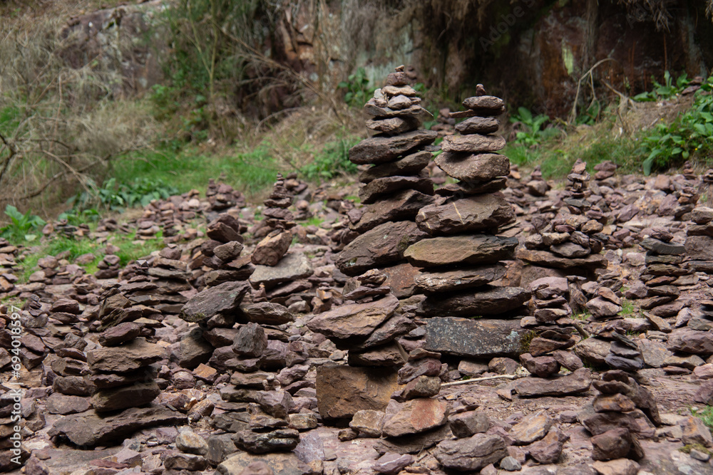 ภาพถ่าย Stock Fitas small piles of stacked flat stones ancient symbols ...