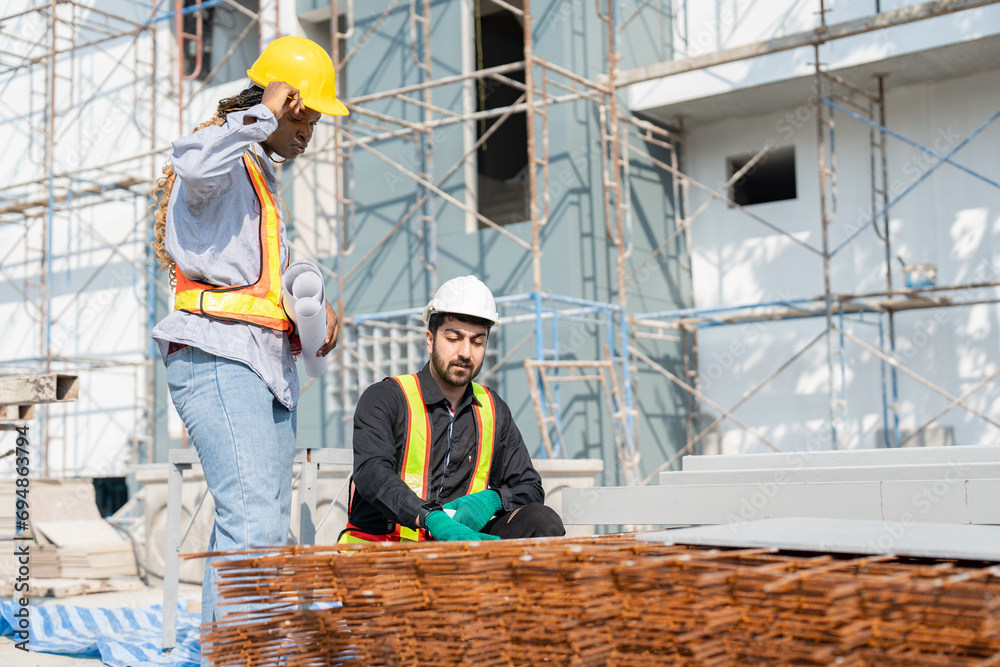 Man engineer and African American woman architect checking steel ...