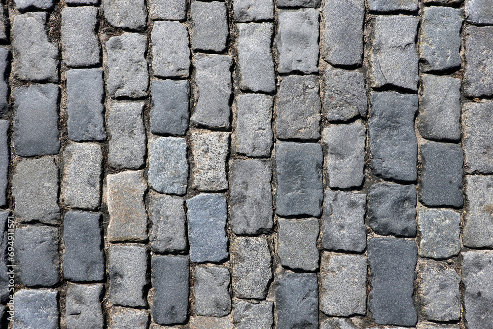 Dark grey cobblestone pavement from old smooth stones as background top ...