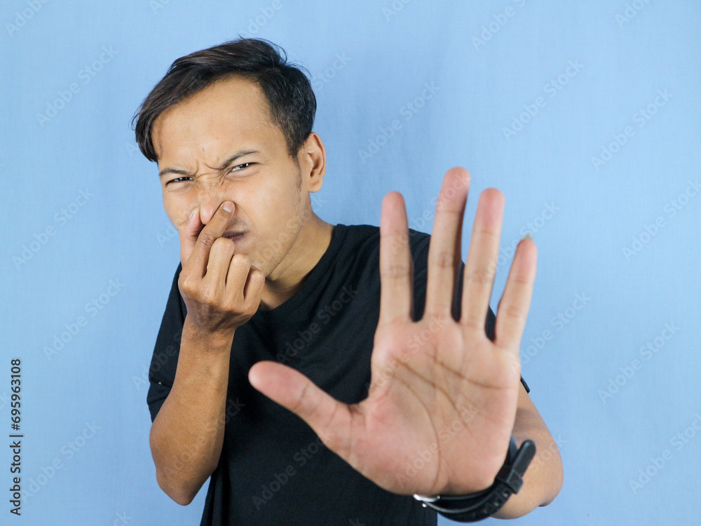 Foto gesture handsome Asian man smelling something stinky and ...