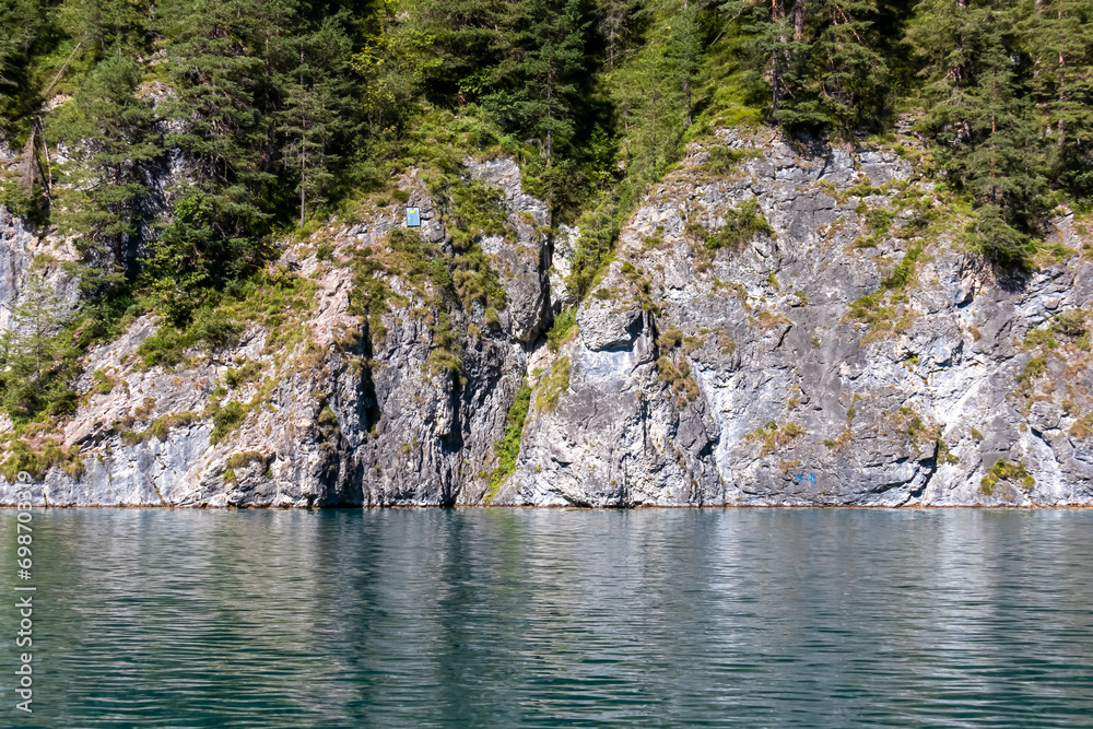 Foto de Stock Rocky cliffs along the lakeshore of alpine lake ...