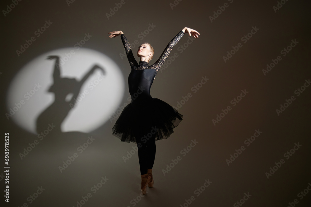 Ballerina demonstrating dance figure during studio photoshoot, her ...