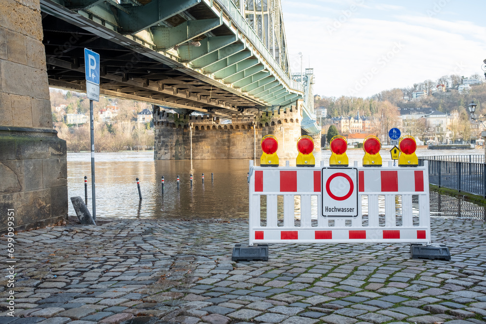 A full river that has burst its banks, and in the foreground is a stop ...