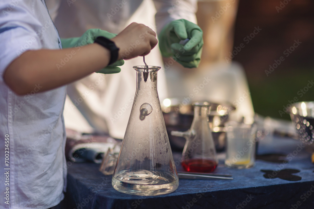 Chemical reaction closeup. Glass flask with puffs of smoke as a result ...