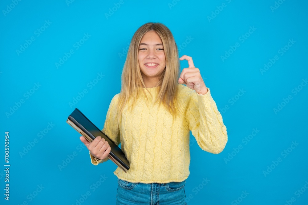 beautiful caucasian teen girl wearing yellow sweater pointing up with ...