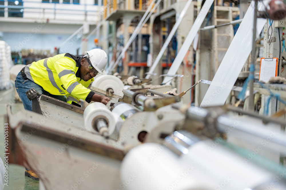 African male engineer standing in engine room Bend down to inspect the ...