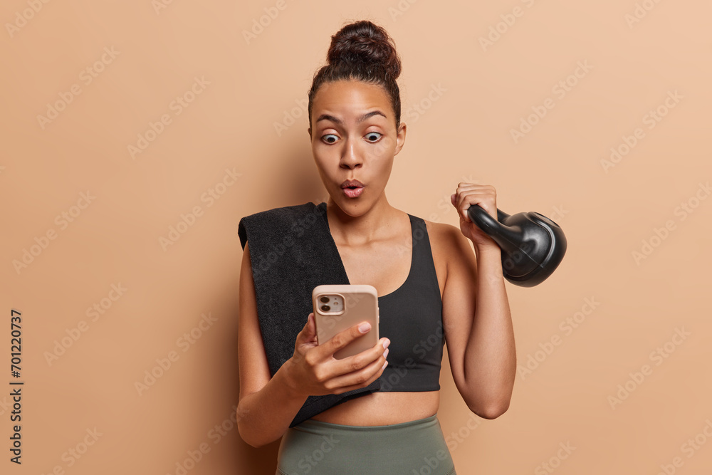 Photo Stock Fit young sporty young woman with hair bun lifts weight for ...