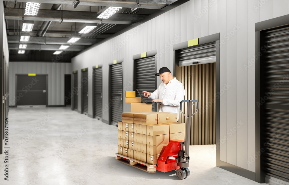 Man near storage room. Warehouse corridor with pallet jack. Man brought ...