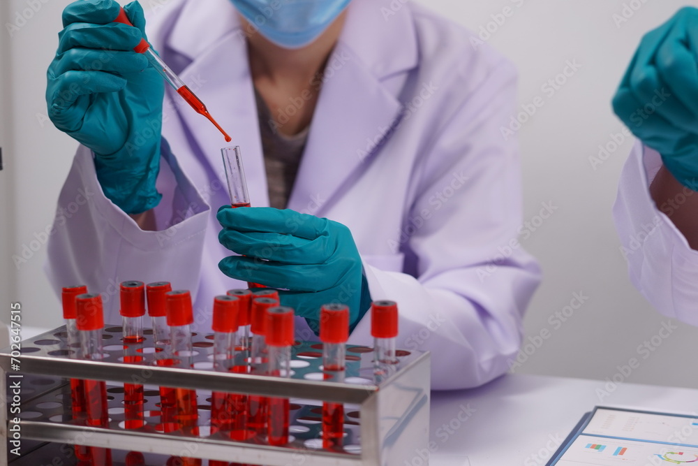 Hands of a doctor or female doctor collecting blood sample tubes from ...