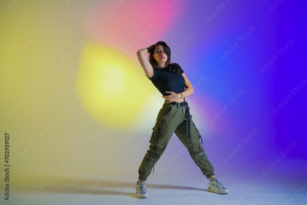 Young woman in black clothes posing in studio with gradient blue ...