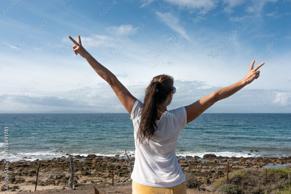 Authentic woman expressing confidence and waving victory signs with ...