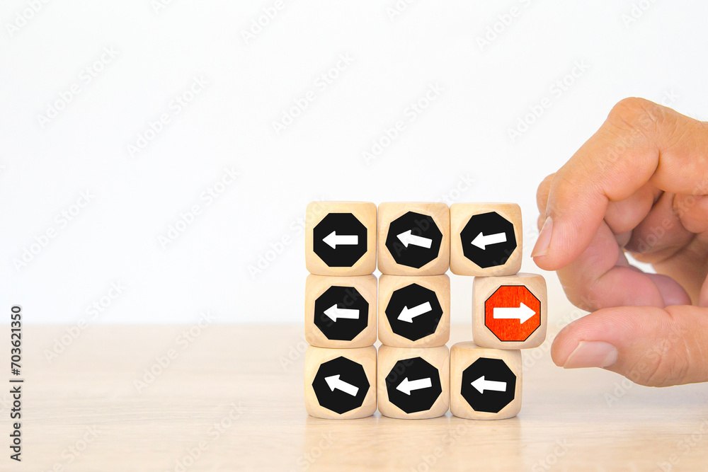 Hand chooses arrow icon point to the opposite side on cube wooden block ...