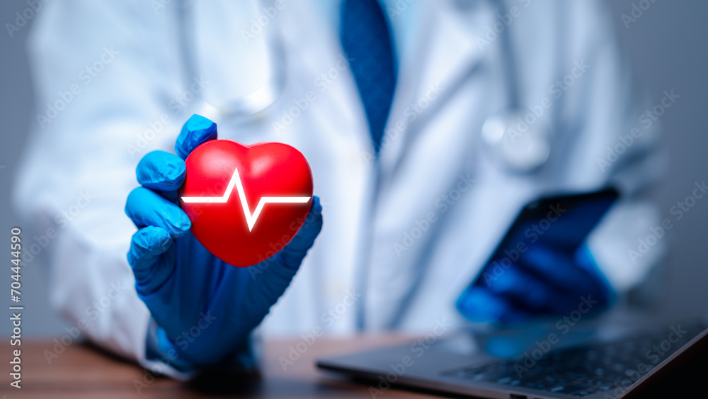 Heart pulse concept. A Doctor's hand holds a red heart, a poignant ...