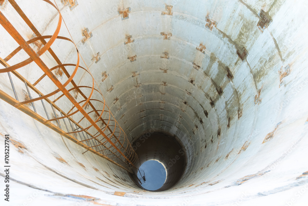 Deep reinforced concrete drainage well with metal stairs. Element of ...