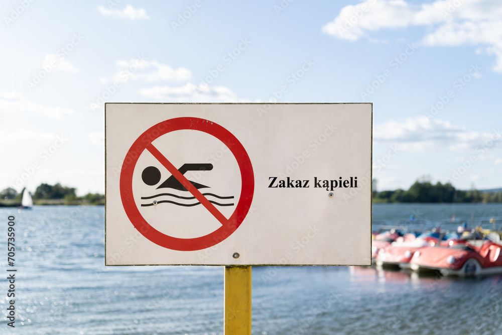 No Swimming sign post plaque, with water in background. No swim area ...
