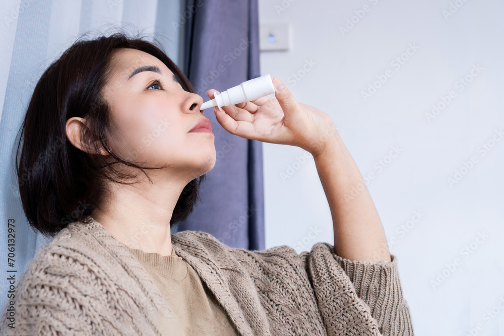 close up Asian woman treating a runny nose with nasal spray for ...
