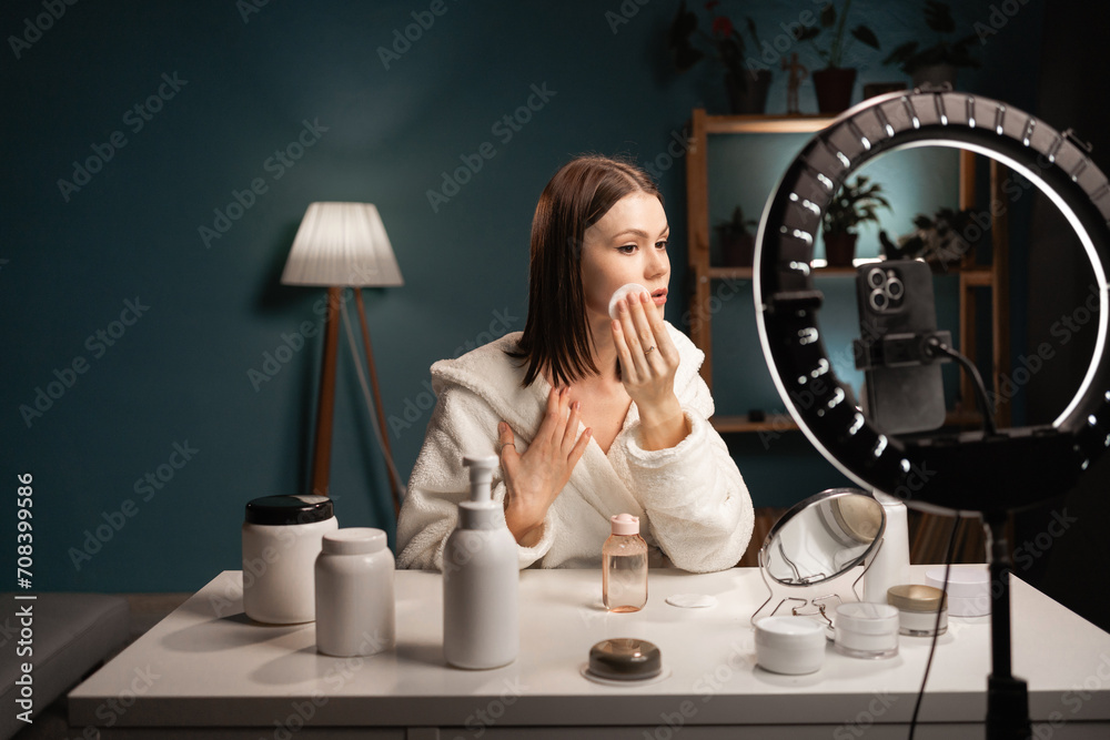 Beauty blogger woman filming daily skin care routine tutorial at camera ...