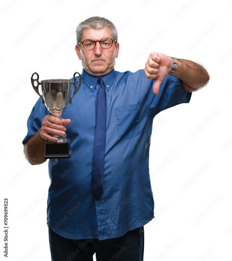 Handsome senior successful man holding trophy over isolated background ...