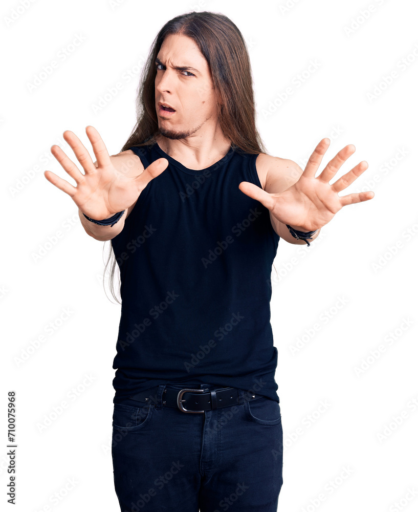 Young adult man with long hair wearing goth style with black clothes ...
